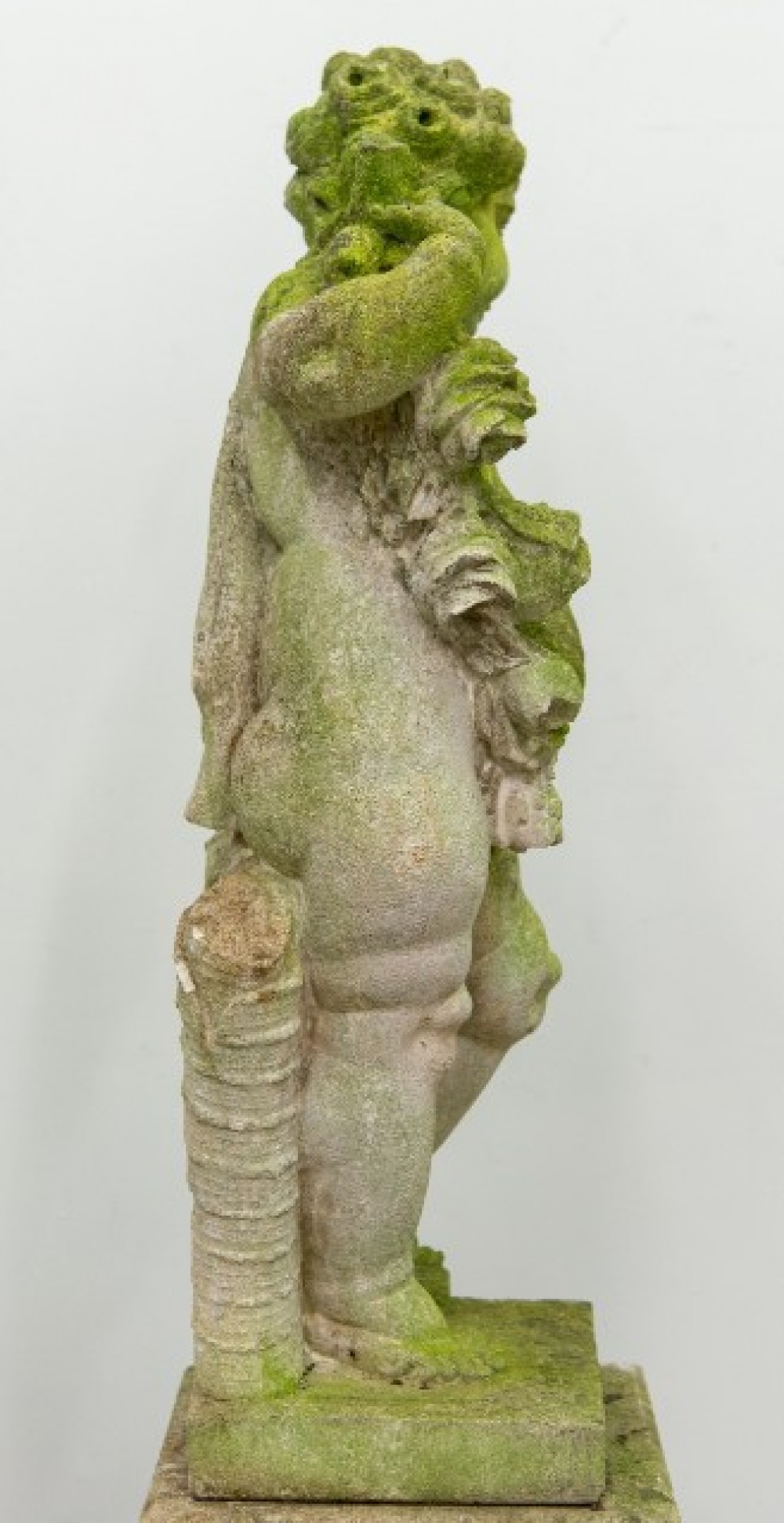 Concrete statue of cherub holding roses on base